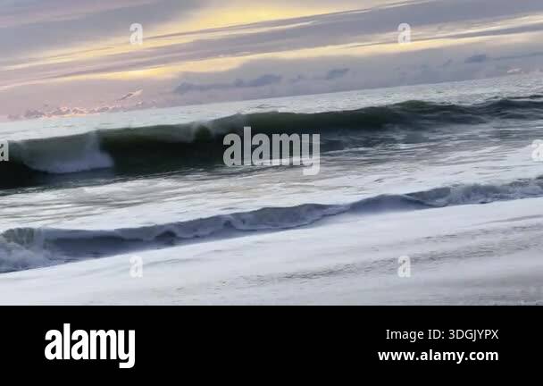 A sunset over the ocean, with vibrant golden and purple tones blending ...