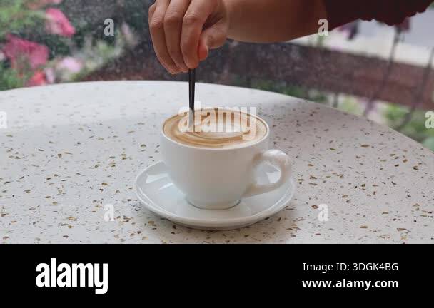 Hand stirring coffee in a white cup Stock Video Footage - Alamy