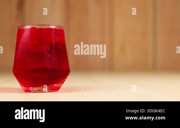 Red drink with ice in a glass Stock Video Footage - Alamy
