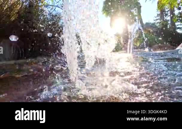 Water splashes from fountain under bright sunlight at zoo Stock Video ...