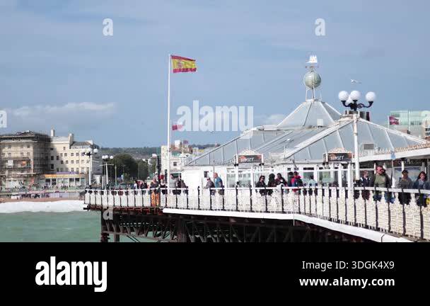 People walking on Brighton Pier, flag waving Stock Video Footage - Alamy