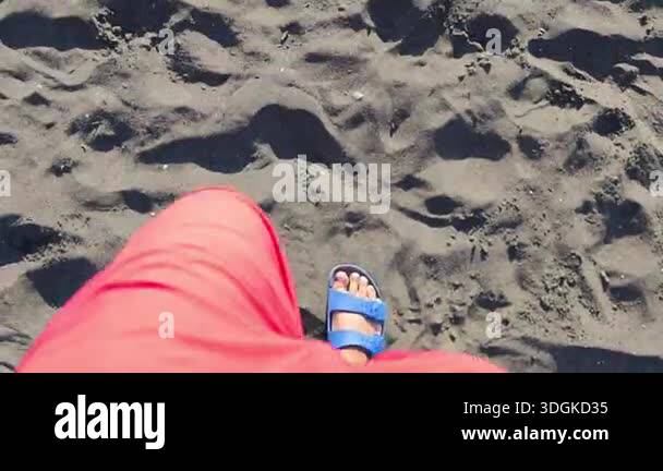 First person view of a mans feet wearing sandals walking on the dark ...