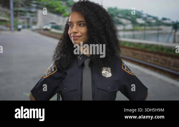 Woman officer in uniform standing confidently at a train station ...