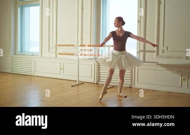 Young ballerina in tutu skirt dancing practicing ballet positions in ...
