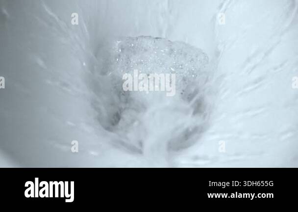Flushing water in a toilet bowl with white clean ceramic in slow motion ...