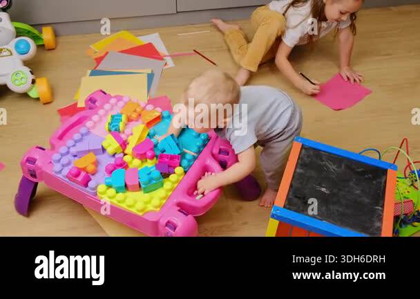 Adorable little brother having fun at home playing together on floor ...