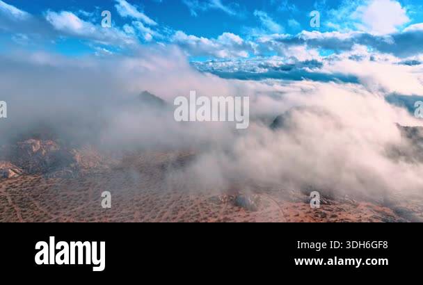 Moving through the white cloudscape floating over the desert. Drone ...