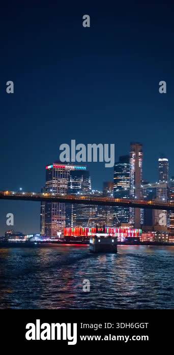 Following a ferry passing under the Brooklyn Bridge. Night river cruise ...
