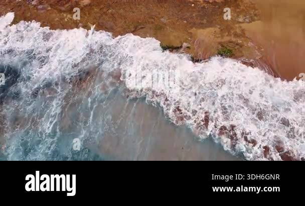 Waves move towards the sand as water swells and breaks along the ...