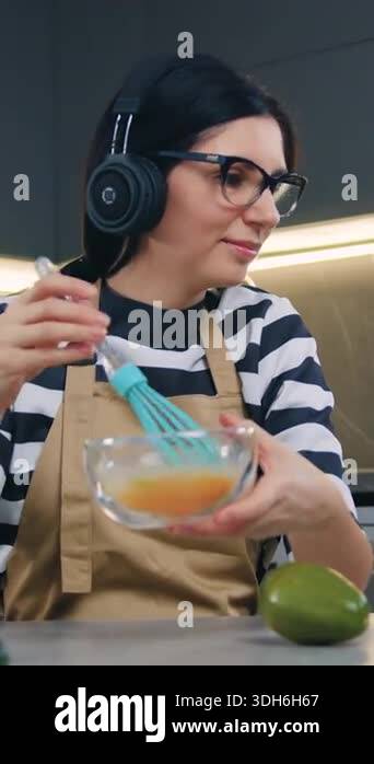 Adorable positive in high spirits dark-haired housewife in apron ...