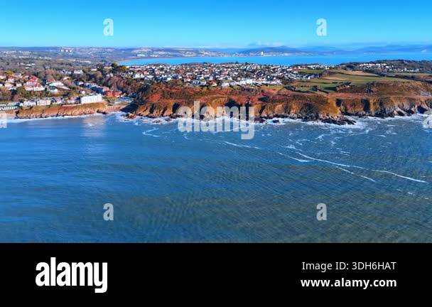 Rocky coast with picturesque residential area on top. Spectacular blue ...