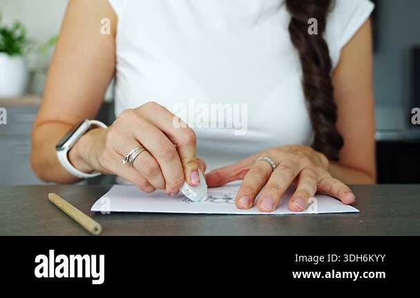 Close up of woman hands erasing pencil doodles with eraser on paper in ...