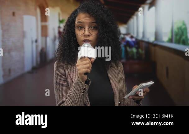 Woman reporter holding microphone on restaurant terrace indoors ...