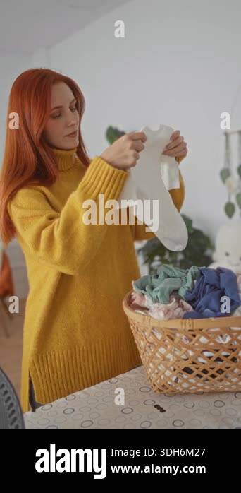 Woman folding clothes in a cozy laundry room at home, showcasing her ...