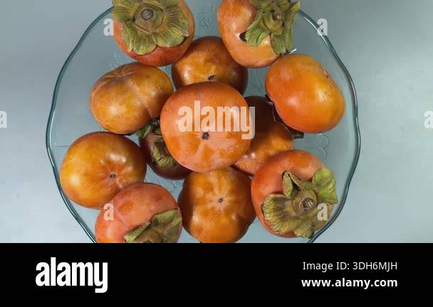 Persimmon fruits Fuyu variety in vintage glass fruit bowl Stock Video ...