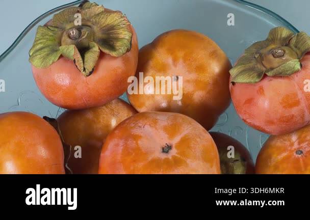 Persimmon fruits Fuyu variety in vintage glass fruit bowl Stock Video ...