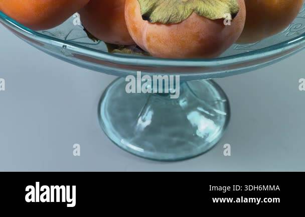 Persimmon fruits Fuyu variety in vintage glass fruit vase Stock Video ...