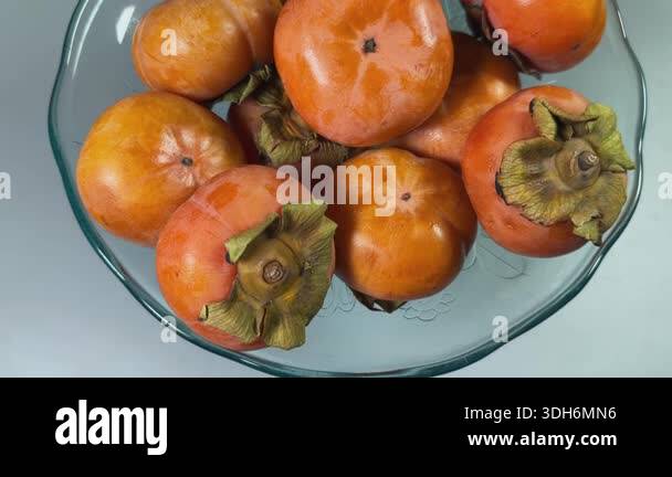 Persimmon fruits Fuyu variety in vintage glass fruit bowl Stock Video ...