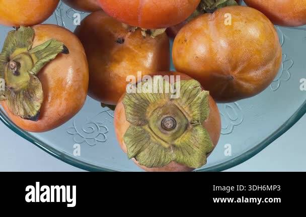 Persimmon fruits Fuyu variety in vintage glass fruit bowl Stock Video ...