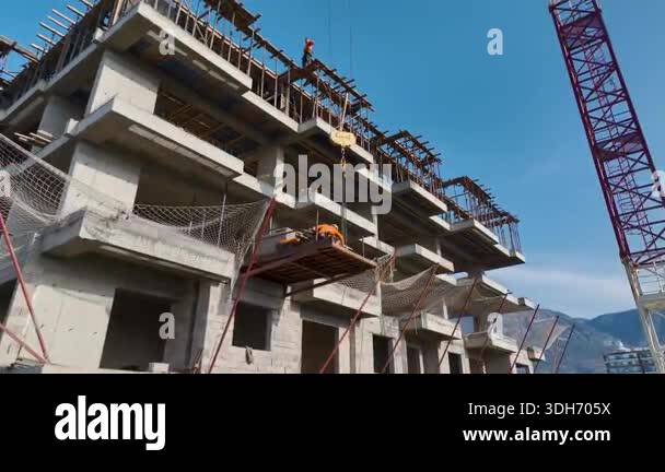 A busy worksite with engineers, workers, and heavy machinery ...