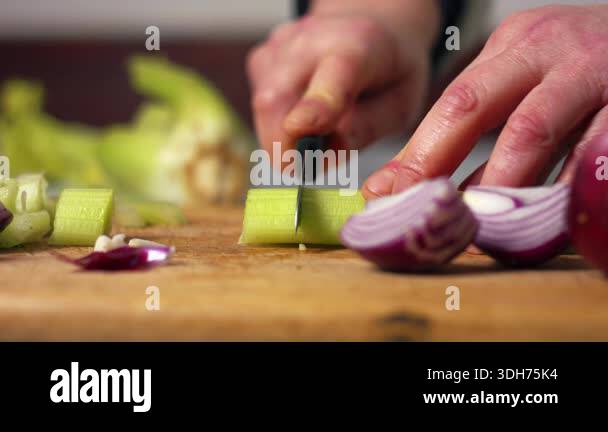 Hand chopping celery with onions close up 4k slow motion shot selective ...