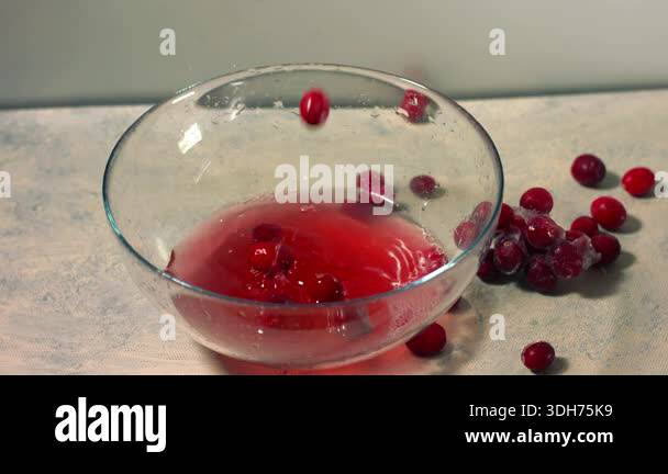 Dropping red ripe cranberries into a bowl medium overhead shot 4k slow ...