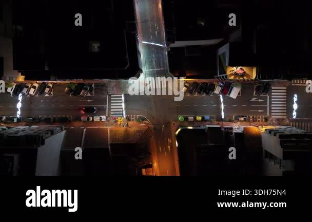 Top down aerial drone view of an urban street intersection at night ...