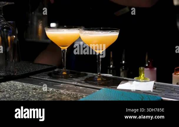 Creative barman splashing lemon juice on cocktail using lighter in ...