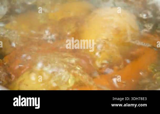Close-up slow motion of boiling vegetables, carrots and potatoes for ...