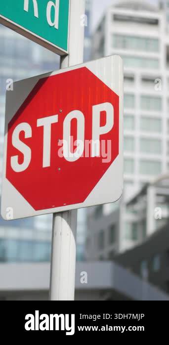 A stop sign stands tall with buildings around it in the daytime Stock ...