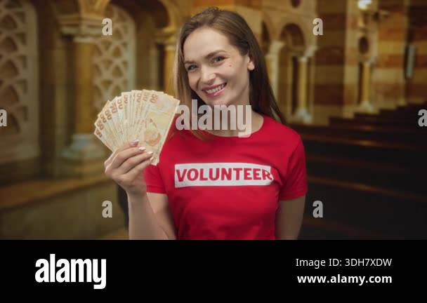 Young caucasian volunteer woman holding a fan of turkish lira banknotes ...