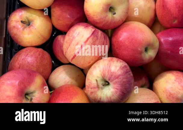 Gala apples arranged in a crate at the greengrocer's, tracking shot ...