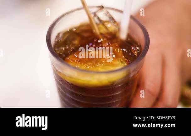 Hand stirring iced tea with lemon slice Stock Video Footage - Alamy