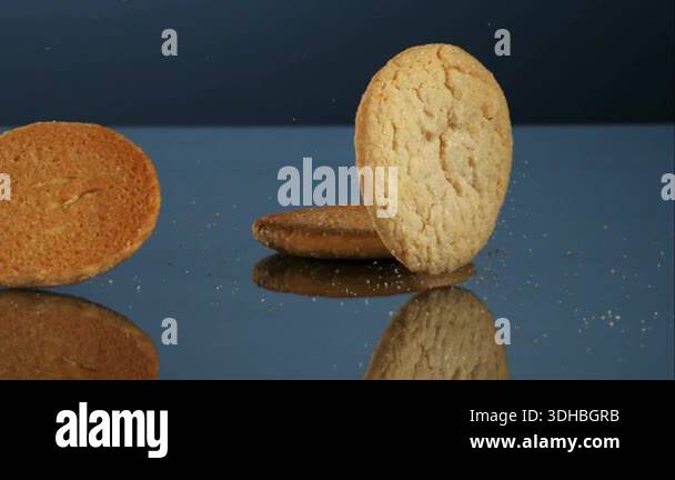 Crispy golden brown sugar cookies falling and stacking onto a blue ...