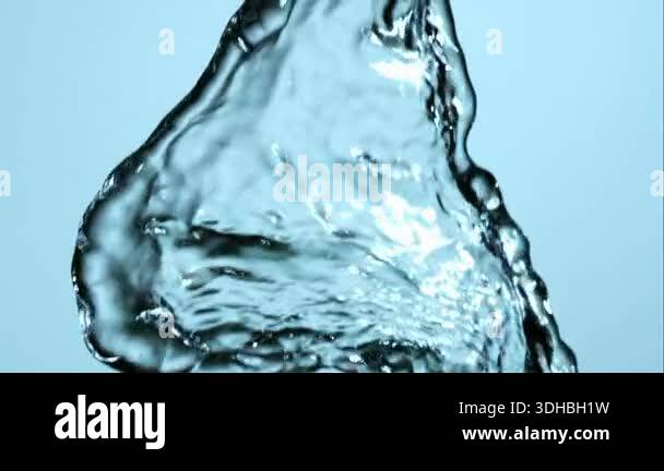 Vertical stream of fresh clear water pouring down in slow motion ...