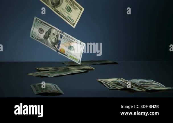 Many one hundred dollar bills falling from above and landing on a dark ...
