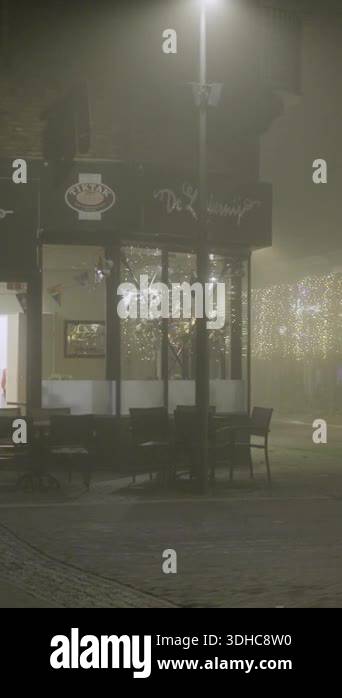 Mysterious empty city street with a closed cafe and christmas lights ...