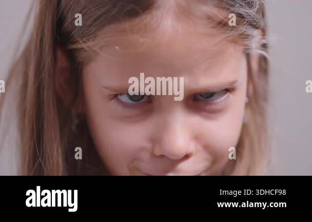 Close-up portrait of a girl making playful faces and changing ...