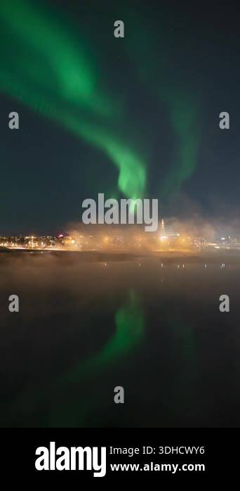 Aurora borealis water mirror reflection over geothermal steam Reykjavik ...