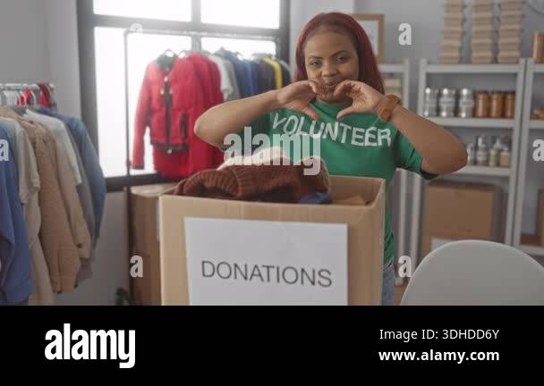 Woman volunteer in green shirt makes heart gesture with hands over ...
