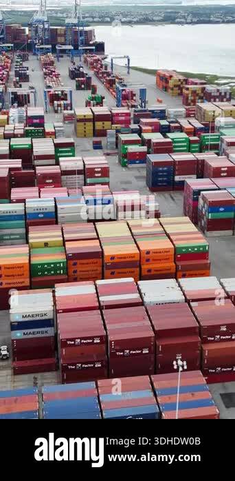Colorful shipping containers stacked at a busy industrial cargo ...