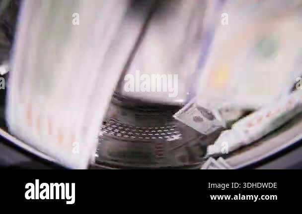 US paper currency spinning around inside a domestic washing machine ...