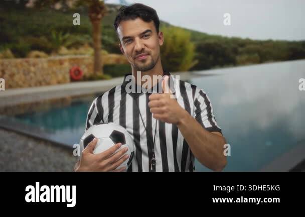 Hispanic soccer referee man smiling and giving thumbs up while holding ...