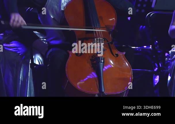 Musician gracefully plays cello with bow over strings creating music ...