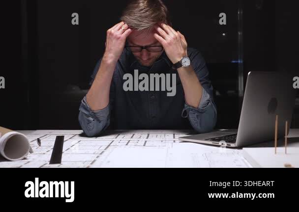 Stressed architect feeling headache and frustration, working late at ...