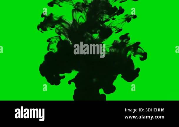 Black ink diffusing in water creating abstract liquid motion on a green ...