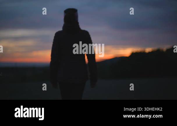 A woman is out of focus as she walks away at sunset Stock Video Footage ...