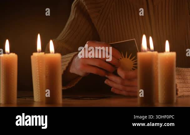 Fortune teller hands under candles fortune-telling on tarot cards ...