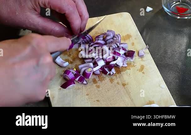 Preparing traditional food, chopping or slicing onion using a knife ...