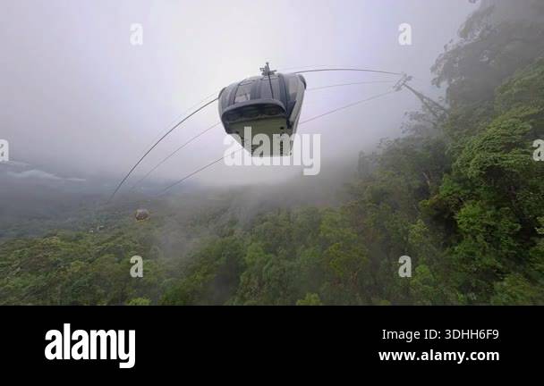 Cable Car Gliding Over Green Mountain Slopes with Low Mist and Cloud ...